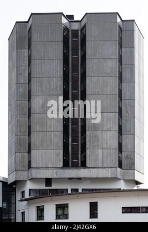 High rise architectural brutalism style apartment building behind metal ...