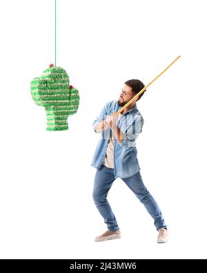 Handsome man breaking Mexican pinata on color background Stock Photo ...