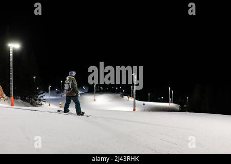 Snowboarder girl posing on slopes. Night skiing in winter resort Stock ...