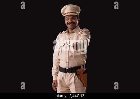 Portrait of an Indian policeman standing with baton in hand Stock Photo ...