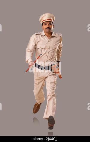 Portrait of an Indian policeman running Stock Photo - Alamy