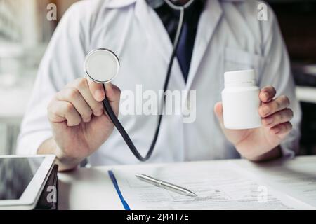 The doctor is carrying a stethoscope and a medicine jar on his hand in ...