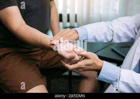 Physical therapist checks the patient wrist by pressing the wrist bone ...