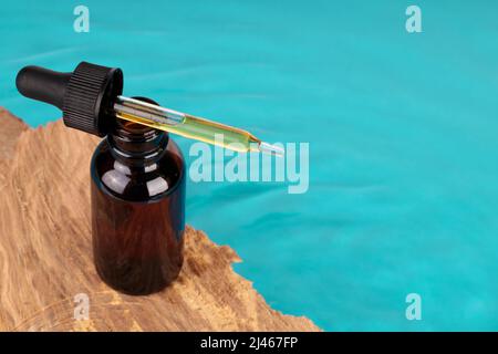 Cosmetic bottle with incendiary, top shot. Brown bottle on wood, blue ...