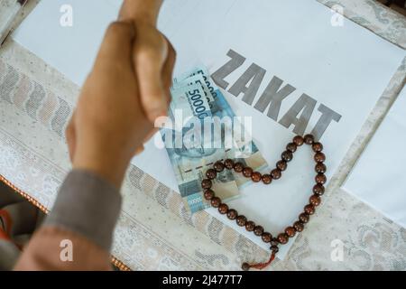 hand shake with money as a payment for zakat donation during ramadan ...