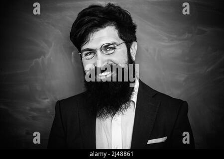 Teachers challenges and inspires. Bearded professor at school lesson at ...