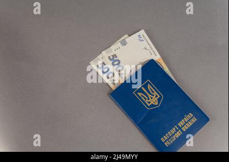 A blue covered passport and cash against a gray background. Ukrainian ...