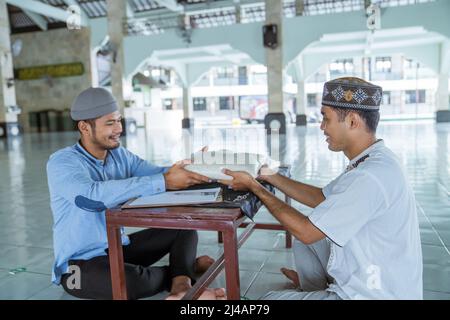 muslim man giving a rice as a food donation for zakat during eid ...