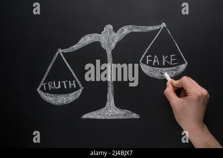 Scales with truth and fake. The concept on the blackboard Stock Photo ...