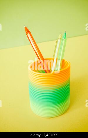 Colorful pens inside a colorful slinky toy Stock Photo - Alamy