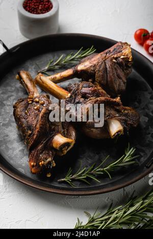 Braised roast Lamb Shanks on a wooden cutting board. White background ...