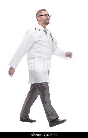 Mature male doctor striding forward. isolated on a white background ...