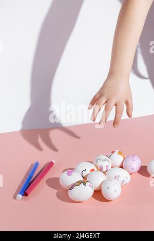 Kid hand paints eggs for easter holidays. Dyeing easter eggs at home ...