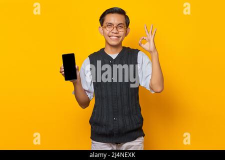 Cheerful Guy Showing Cellphone Gesturing Thumbs Up Over Yellow ...