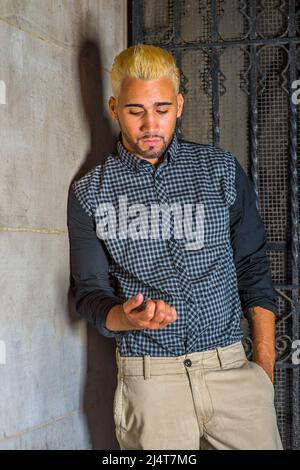 Young hispanic man with beard wearing casual blue sweater pointing to ...