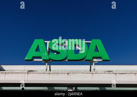 A green Asda supermarket sign against a clear blue sky Stock Photo - Alamy