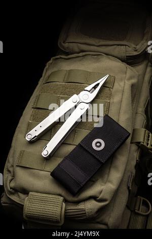 Modern multitool with many tools. A portable multitasking tool lie on a ...