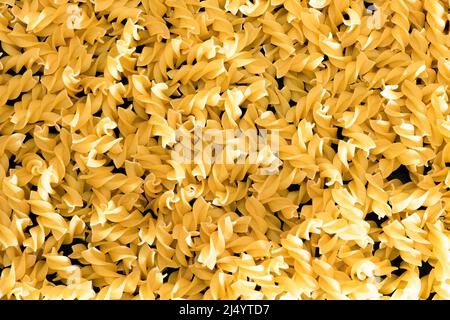 Uncooed Fusilli Pasta - Background. Texture of Bright Golden Dry ...