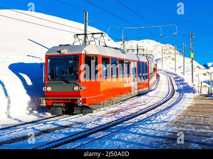 Red train running on rack railway through snowy Swiss Alps Stock Photo ...