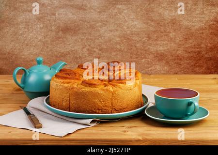 Homemade cinnamon rolls from yeast dough and cup of tea on wooden table ...