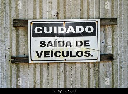 Warning sign in portuguese informing "Attention, entry and exit of ...