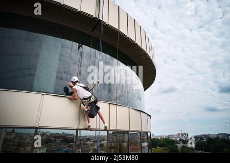 Industrial mountaineering worker professional cleaner hanging on ...