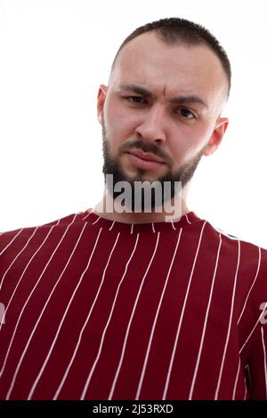 Disgruntled young man with a beard in a Santa Claus hat holds five gift ...
