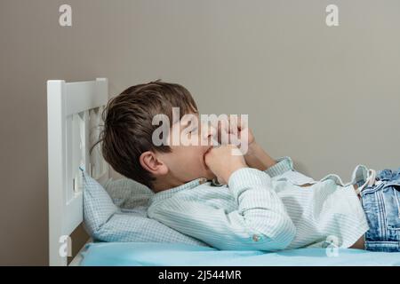Boy with autism spectrum disorder bite hand and negative expression ...