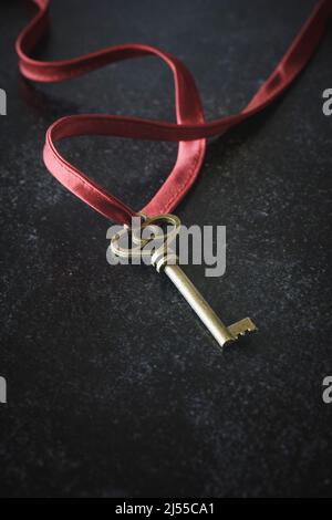 Vintage keys with a red ribbon on dark blue background Stock Photo - Alamy