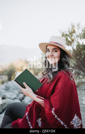 Young woman in hat reading book on beige background Stock Photo - Alamy