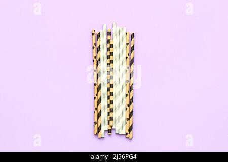 Stylish straws for drinks on purple background Stock Photo - Alamy