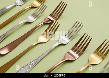 Many different forks on green background Stock Photo - Alamy