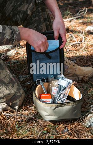 First aid kit and military uniform on khaki background, flat lay. Space ...