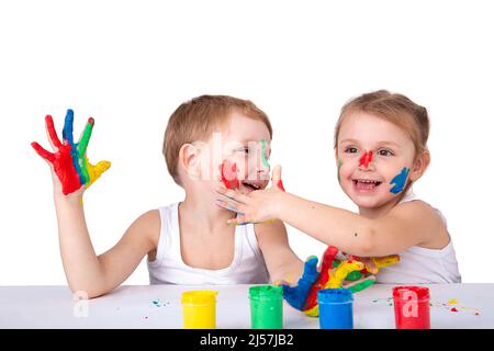 Small children draw on each other with finger paints on a white ...
