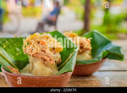 Vigoron with leaves served on a wooden table, two vigorones served on ...