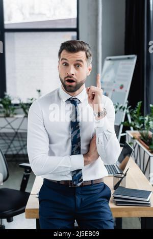 bearded economist with analytics looking at camera near flip chart in ...