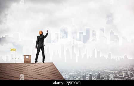 Man architect draw silhouette of modern city on blue sky. Mixed Stock ...