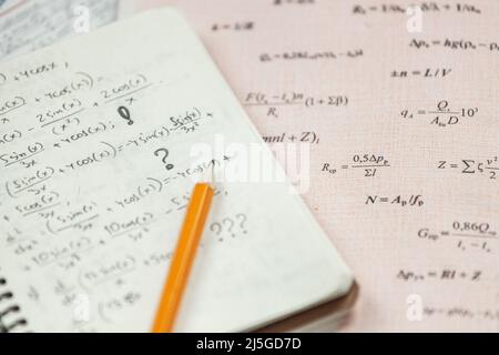 Math formulas are written in pencil on a piece of paper, math problems ...