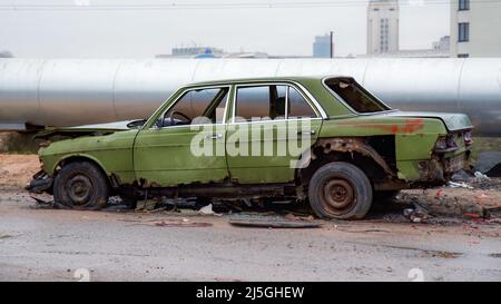 Completely wrecked green car. Side view Stock Photo - Alamy