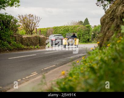 a yellow singer super 9 sports roadster automobile driving top down ...