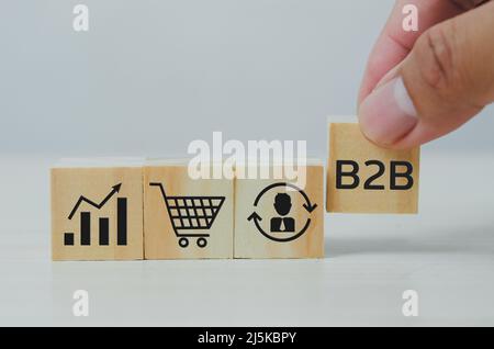 Hand put wooden cubes with B2B Business to Business on table and copy ...