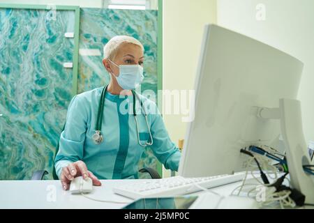 Female physician staring into computer screen during work Stock Photo ...