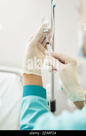 nurse drawing fluid from a vial with a needle or syringe Stock Photo ...