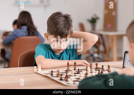 Little children playing chess during tournament in club Stock Photo - Alamy