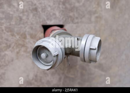 Double fire hydrant near the city wall closeup Stock Photo - Alamy
