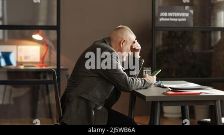 Serious mature candidate for job using mobile phone while sitting at ...
