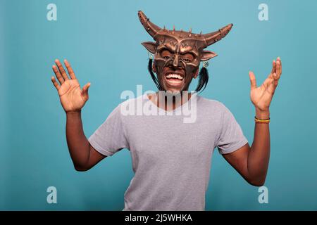 Young man wearing ancient tribal mask with sacral pattern and design ...