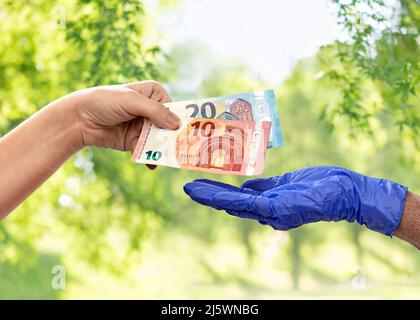 hand in medical glove with money at atm machine Stock Photo - Alamy