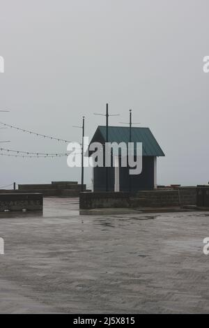 A simple and plain wooden shack standing on the waterfront pier during ...