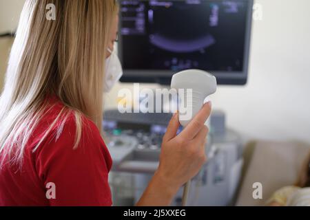 Doctor holding ultrasonic sensor in his hands to examine patients ...